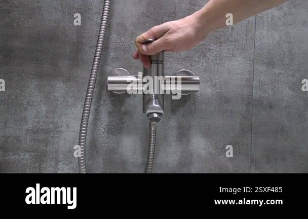 Professional plumber checking water pressure by manipulating chrome ...