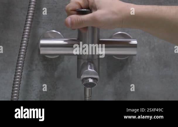 Professional plumber checking water pressure by manipulating chrome ...