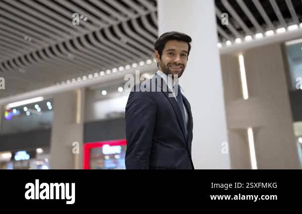 Business man looking at camera while standing at white background ...