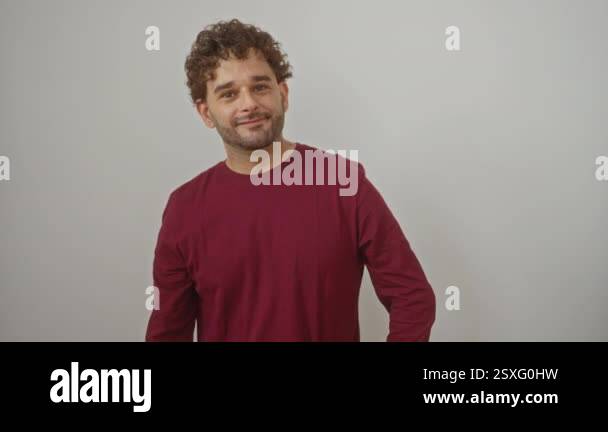 Young hispanic man standing wearing t-shirt, victory sign showing ...