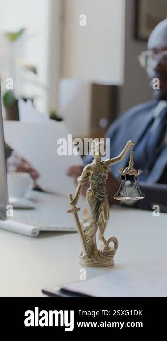 Vertical medium closeup of bronze statuette of Lady Justice holding ...