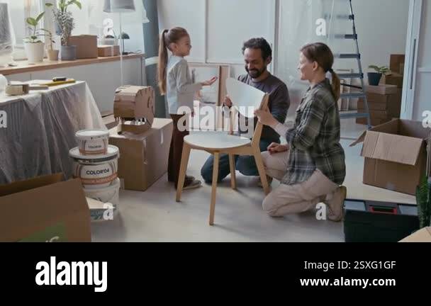 Modern young family of three sitting on the floor of living room of ...