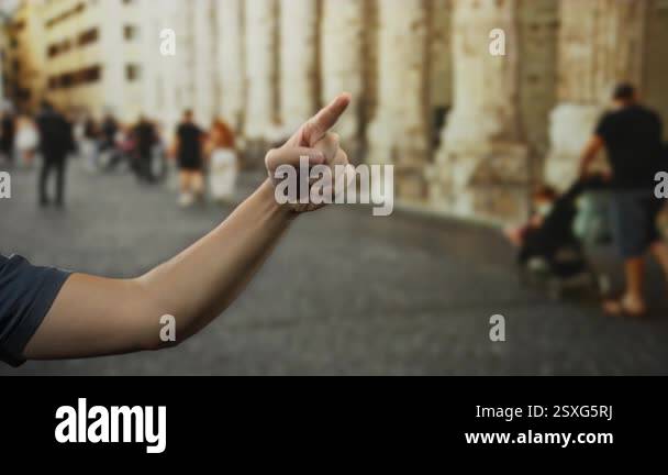 Man's hand pointing with index finger in an outdoor setting at ...