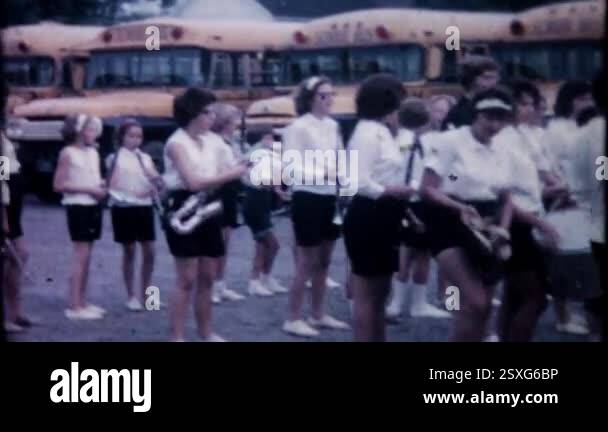 high school marching band, off the bus, lines up for a parade and ...