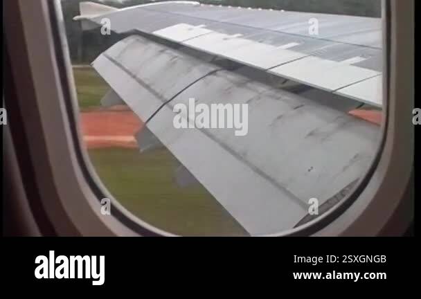 The close-up view of an airplane's wing, captured through window during ...