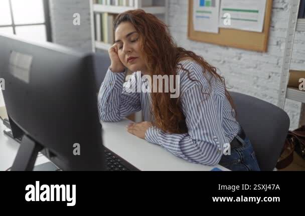Woman sleeping at desk in modern office feeling tired and exhausted ...
