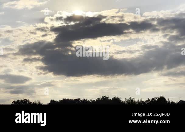 Sunlight breaking through cumulus cloud at sunset. Sun going down ...