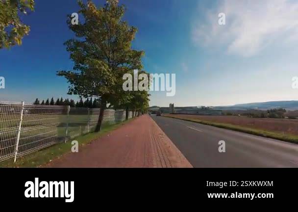 POV: Driving along a rural town road in autumn. FPV riding along a road ...