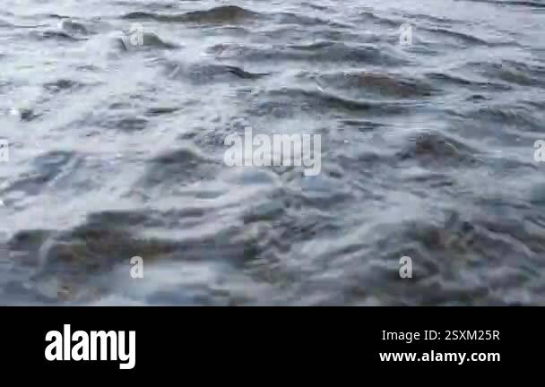 Transparent shallow surface revealing dark seabed through gently ...