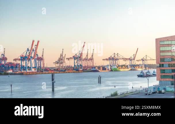 Aerial timelapse of Hamburg cargo port at sunset, showcasing container terminals, cranes and ...