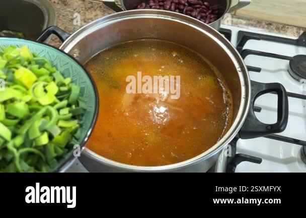 Adding chopped leek stems to a pot. The process of making Ukrainian ...