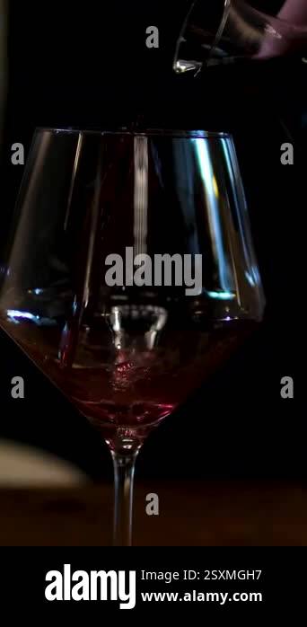 Pouring Red Wine. Slow Motion. Red Wine is poured into the glass on a ...