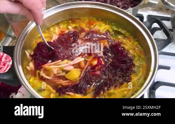 Stirring chopped vegetables, beets, potatoes, carrots, leek stems ...