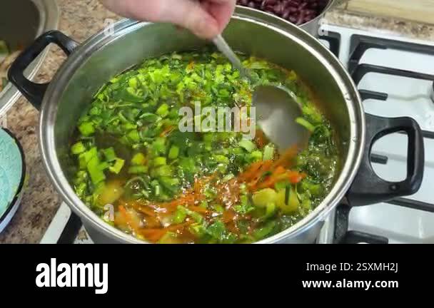 Stirring chopped vegetables, potatoes, carrots, leek stems and cabbage ...