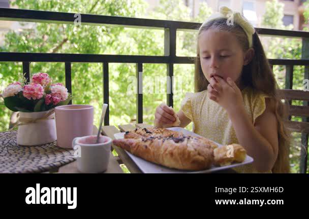 Close-up view of cute kid eating tasty pastry while having brunch ...