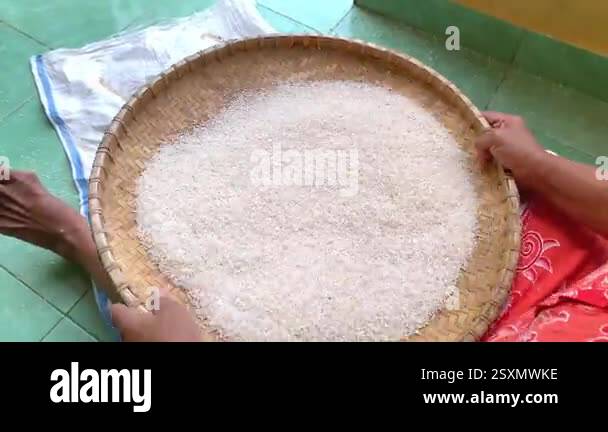 winnowing and cleaning rice on a round rattan tray Stock Video Footage ...