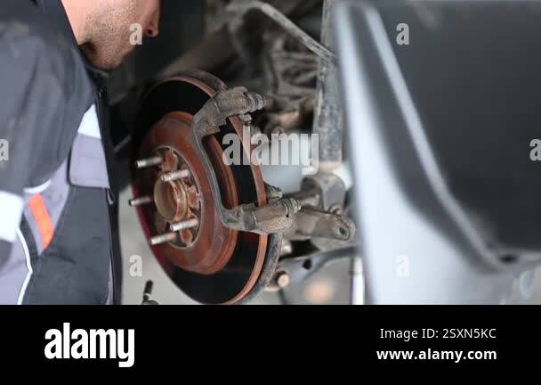 Close-up of a car mechanic replacing the brake discs on a vehicle in a ...