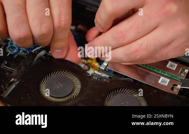 Removing cooling system while disconnecting power cable from laptop ...