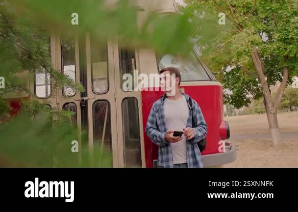 Preparing for a trip: man with a backpack uses his phone to find his ...