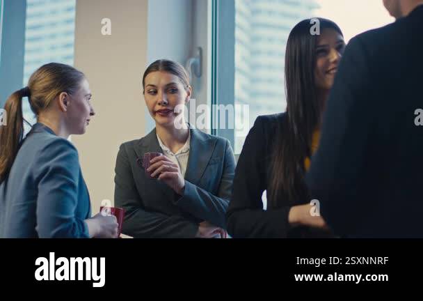 Businesswoman gossiping about a colleague during an office coffee break ...