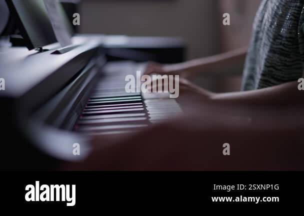 Close-up of a childs hands playing the keyboard, fingers delicately ...