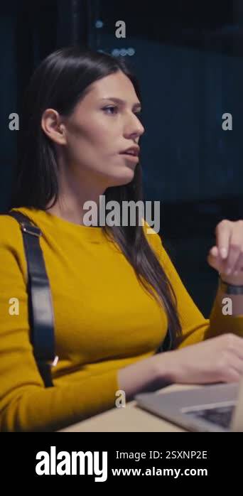 Vertical: Confident young businesswoman in a yellow sweater actively ...