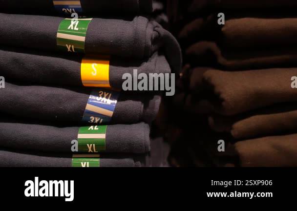 Customers explore clothing options in a retail store with organized ...