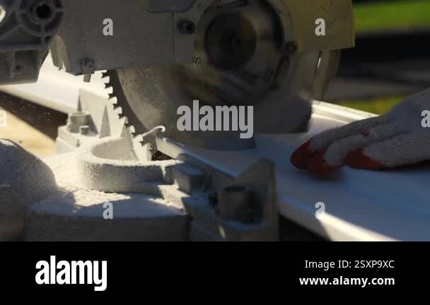A close-up of a circular saw cutting through a piece of material ...