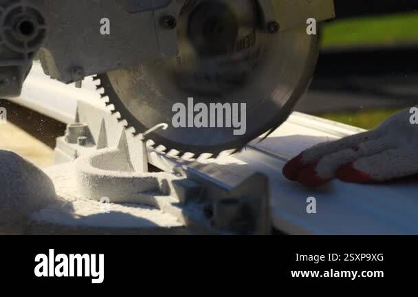 Close-up of a circular saw cutting through a piece of material, plastic ...