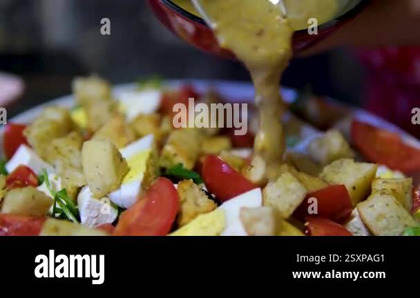 woman chef mix fresh baby cos salad and pour salad dressing in glass ...