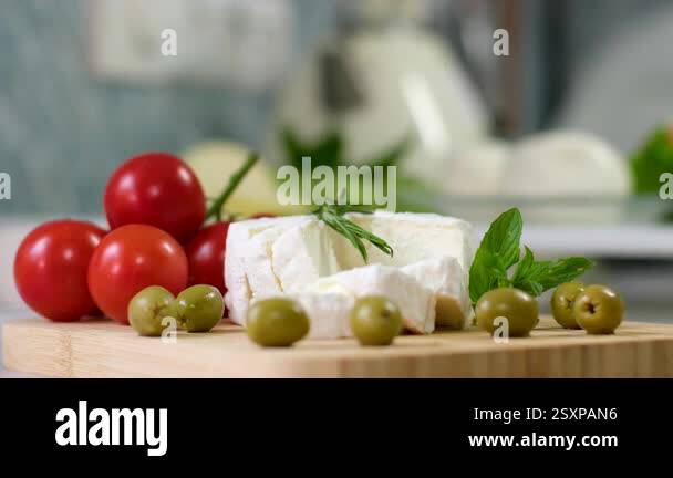 a worker at a craft cheese factory turns over cheese blanks production ...