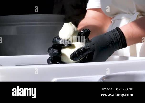 hands of skilled unrecognizable female factory worker in rubber gloves ...