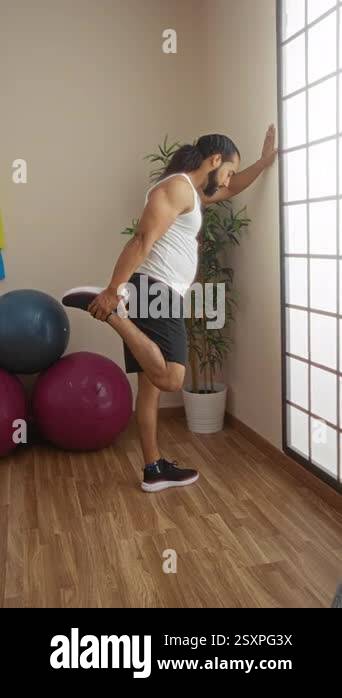 Man stretching indoors in wellness center near window with exercise ...