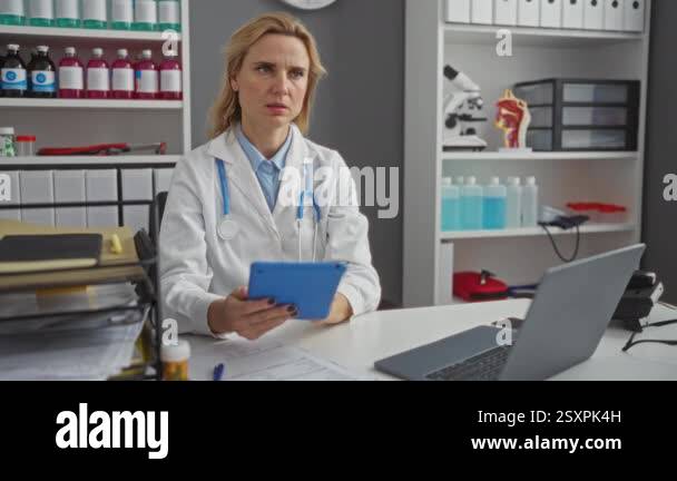 Woman doctor using tablet in clinic office surrounded by medical ...