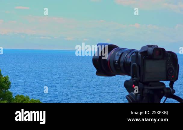 black professional photo camera shooting seaside or lakeside at sunny ...