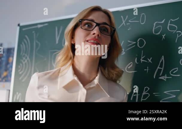 College teacher teaching class showing physics formulas on blackboard ...
