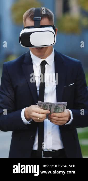 Vertical Video of Rich man wearing virtual reality headset counting ...