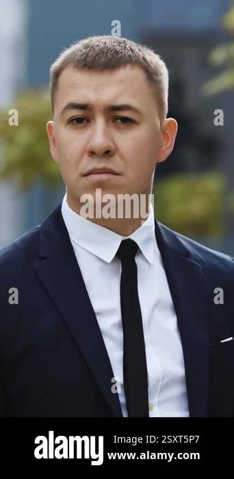 Vertical Video of handsome nice entrepreneur in formal suit standing ...