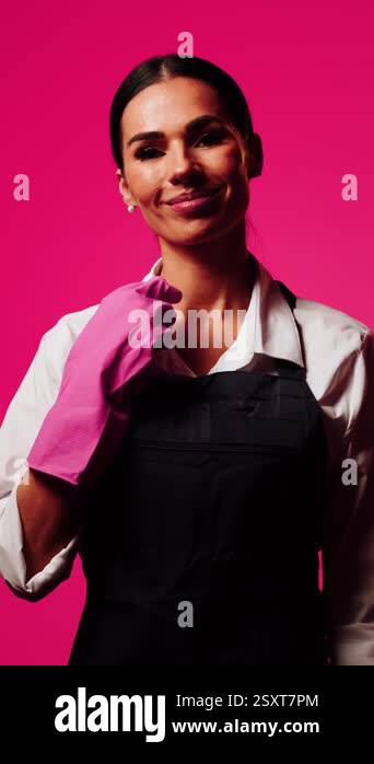 Woman cleaning with tools in a vibrant pink background showcasing house ...