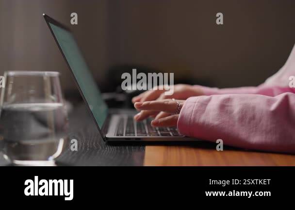 Muslim womans hands hover over laptop keyboard as she navigates digital ...