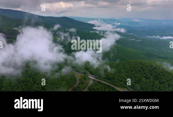 Winding parkway road in mountain forest with green canopies in ...