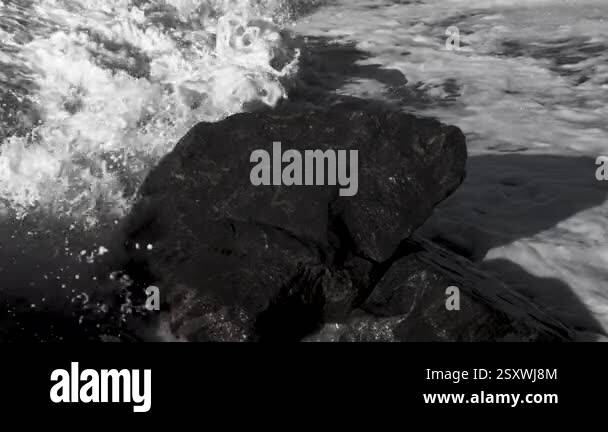 Video of dramatic ocean waves crash against dark coastal rocks ...