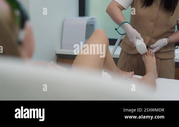 Laser hair removal procedure on a womans toes in a cosmetology clinic ...