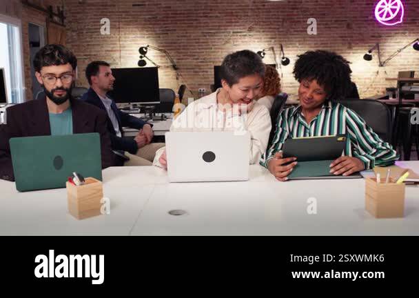 Team members with diverse backgrounds collaborating, using digital ...