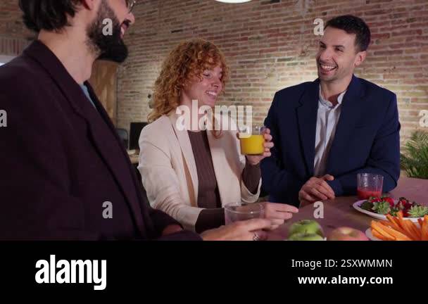 Business partners enjoying healthy snacks and drinks, discussing work ...