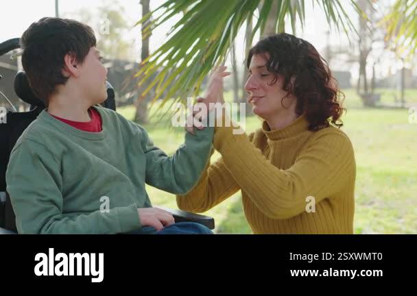 Woman therapist interacting with a disabled child in a wheelchair ...