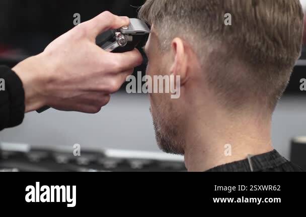 Close up of barbers hands using electric razor, creating precise ...