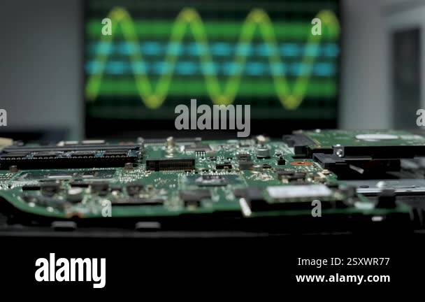 A circuit board is placed in the foreground while an oscilloscope in ...