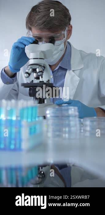 Male scientist researcher wearing lab coat, blue protective gloves ...