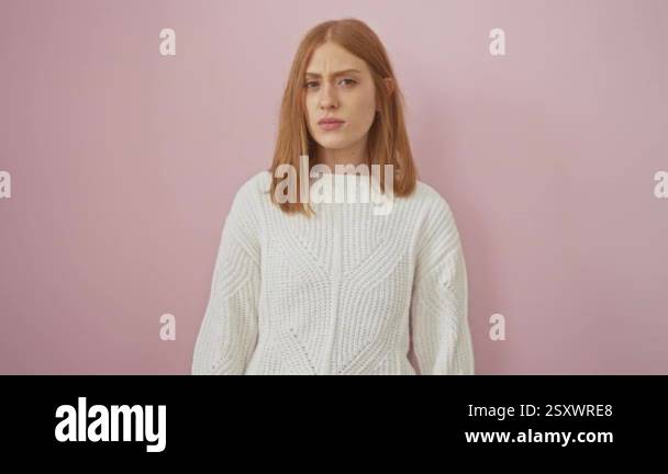 Frowning young redhead woman standing upset over pink background ...